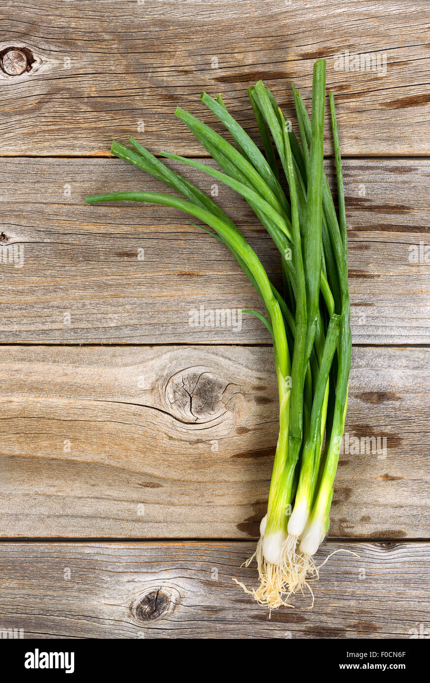 Fresh green onions on rustic wood. Top view of image in vertical format ...