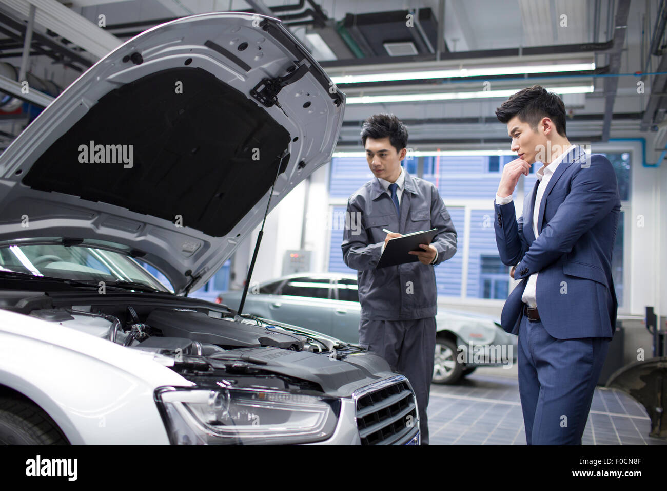Auto mechanic and car owner Stock Photo - Alamy
