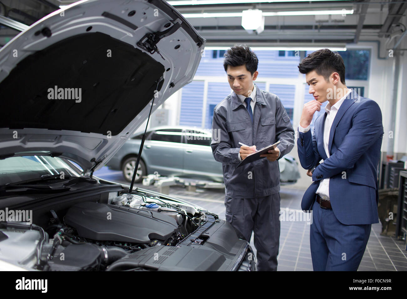 Auto mechanic and car owner Stock Photo - Alamy