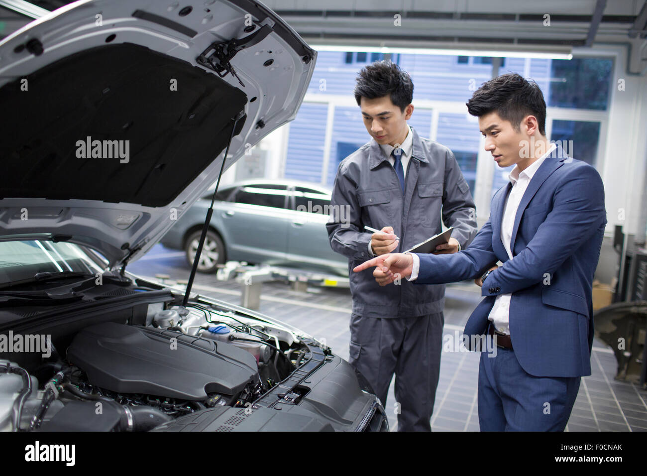 Auto mechanic talking with car owner Stock Photo - Alamy