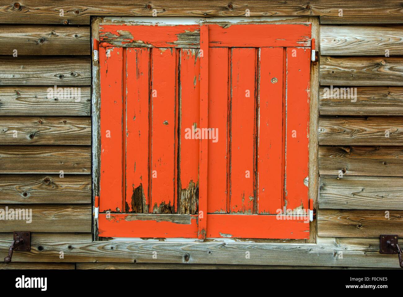 Old Orange Painted Wooden Window Covers in Rustic Wooden Cabin Stock ...