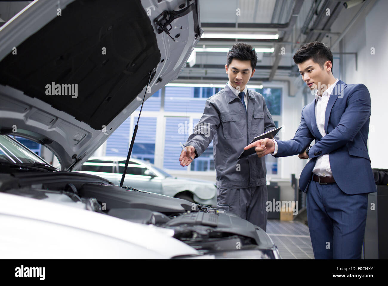 Auto mechanic talking with car owner Stock Photo - Alamy