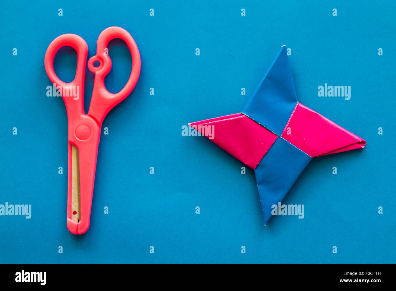 Pink toy scissors and fabric on blue paper background Stock Photo - Alamy