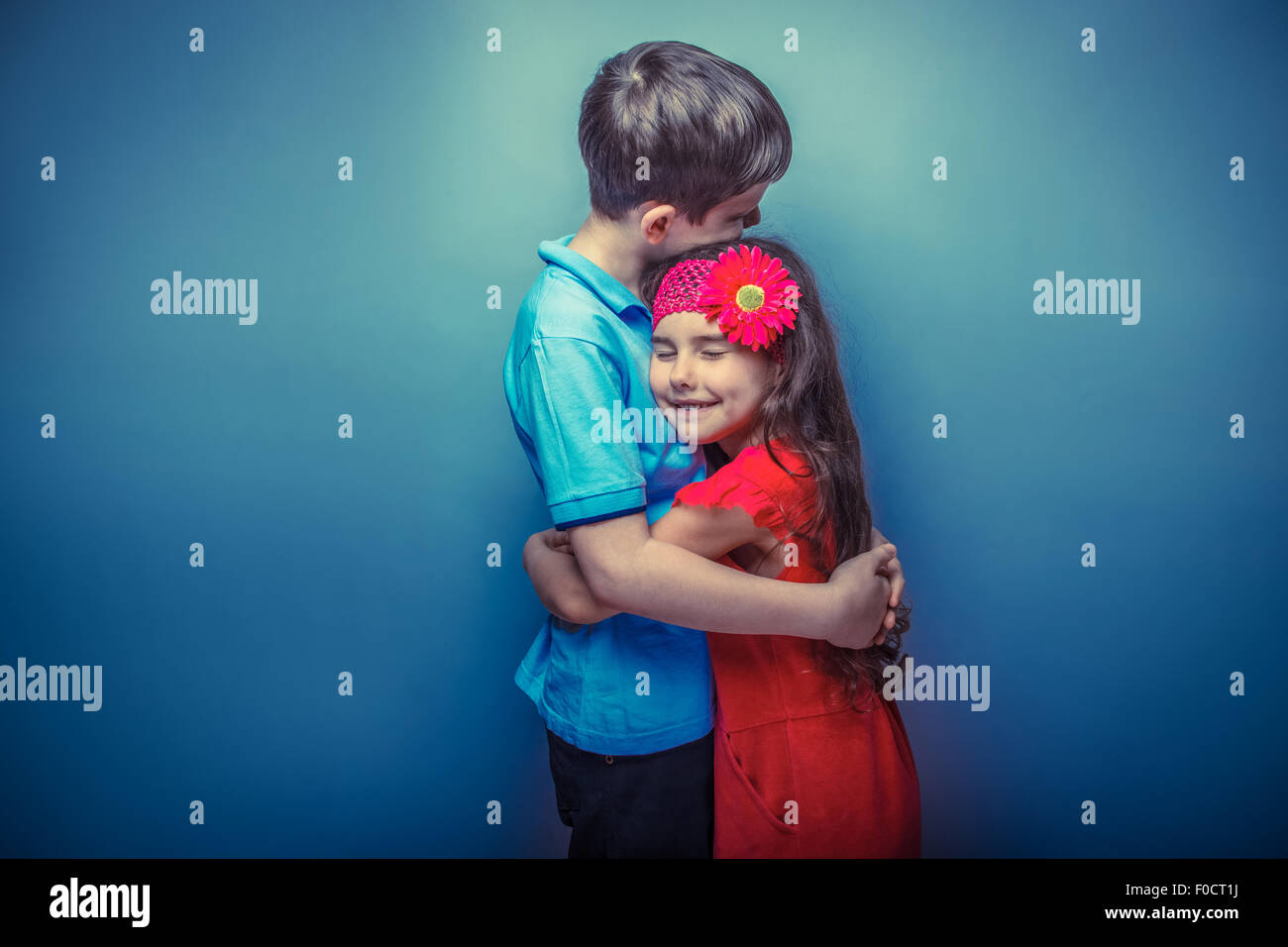 teen girl hugging a teenage boy on a gray background retro photo effect ...