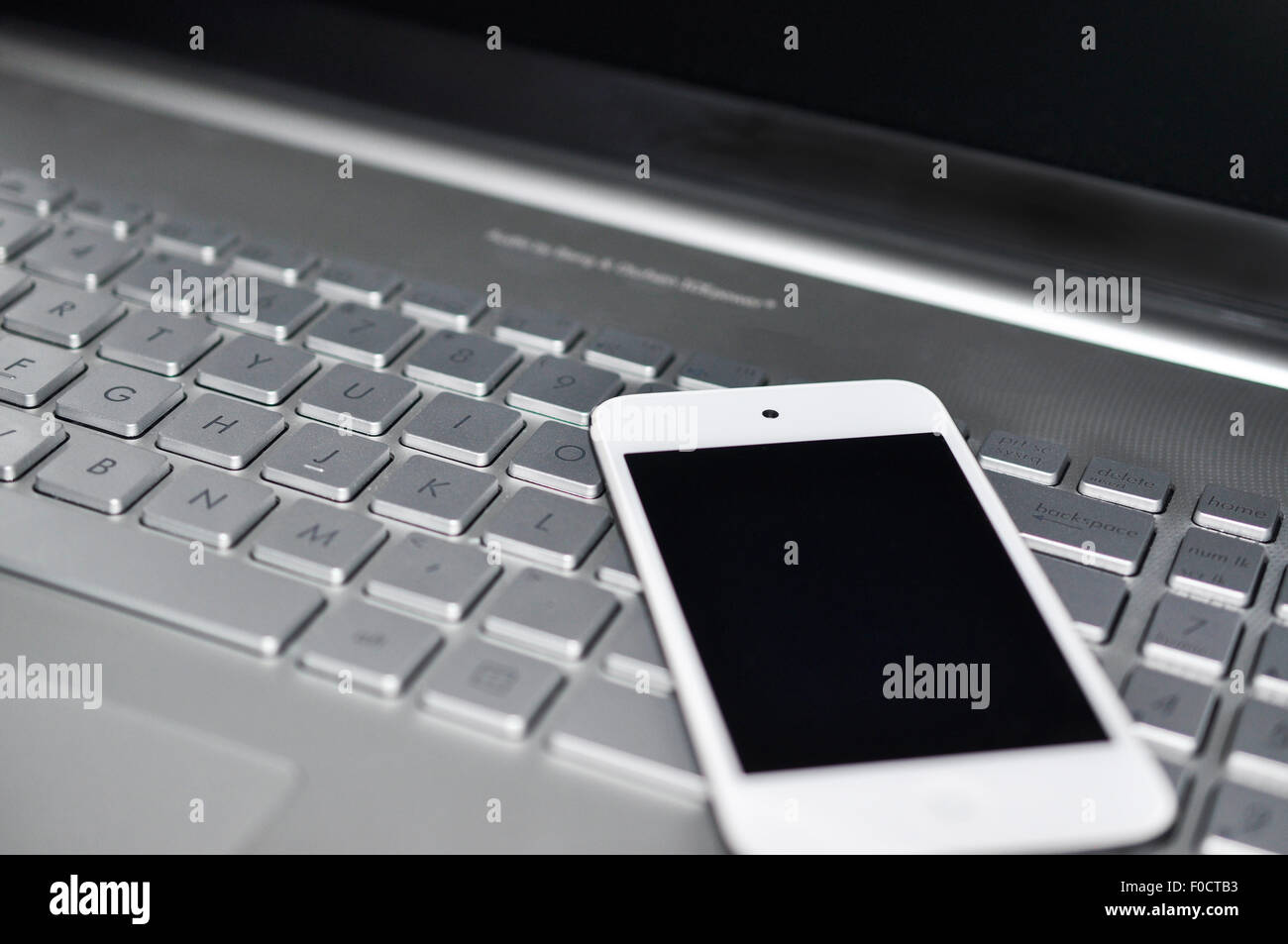 Closeup picture of a keyboard with a phone lying above it Stock Photo ...