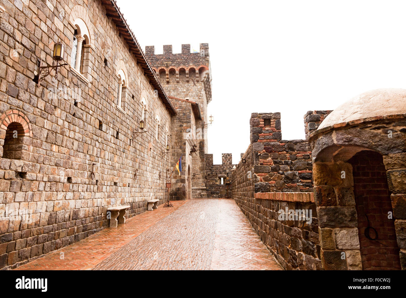 Looking down a walkway of a stone and brick castle entranceway with an ...