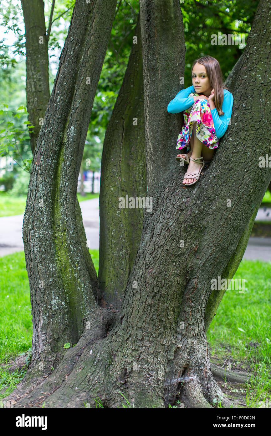 Girl sitting on branch of tree hi-res stock photography and images - Alamy