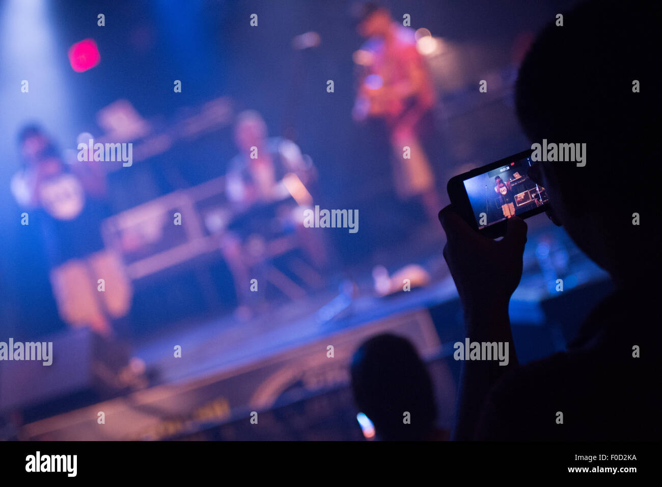 Fan records a band performing live on his cell phone Stock Photo - Alamy
