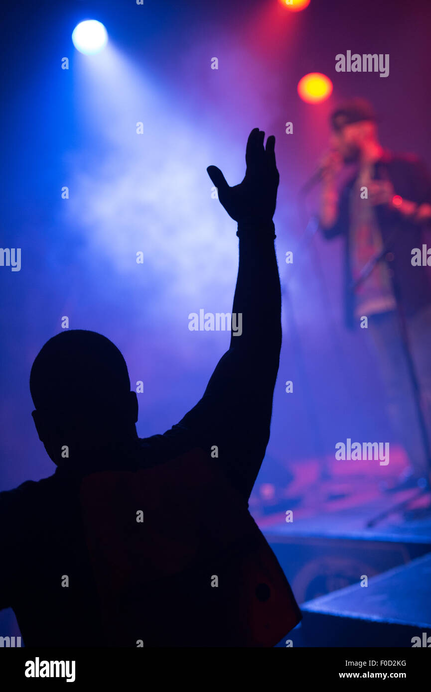 Fan in silhouette waves arms to on stage rapper Stock Photo - Alamy
