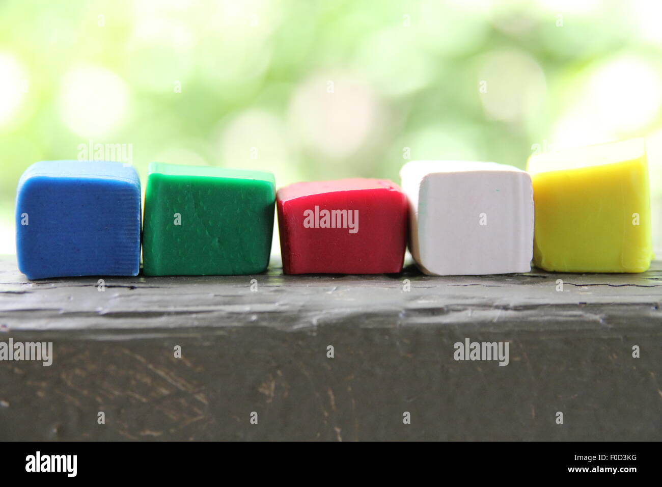 five coloured blocks sitting on a ledge Stock Photo - Alamy