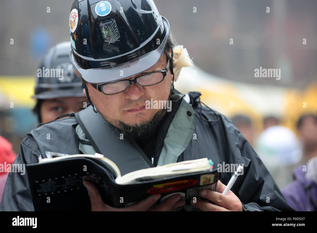 Director Shinji Higuchi looks at his storyboard during filming his ...