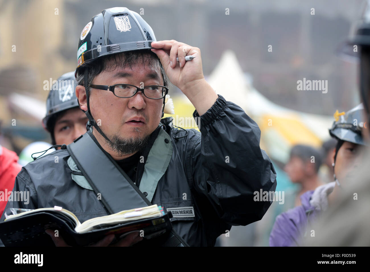 Director Shinji Higuchi adjusts his helmet during filming his "Attack ...