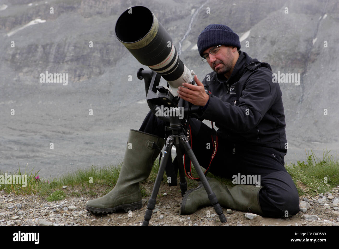 Photographer, Grzegorz Lesniewski, adjusting camera with long lens ...