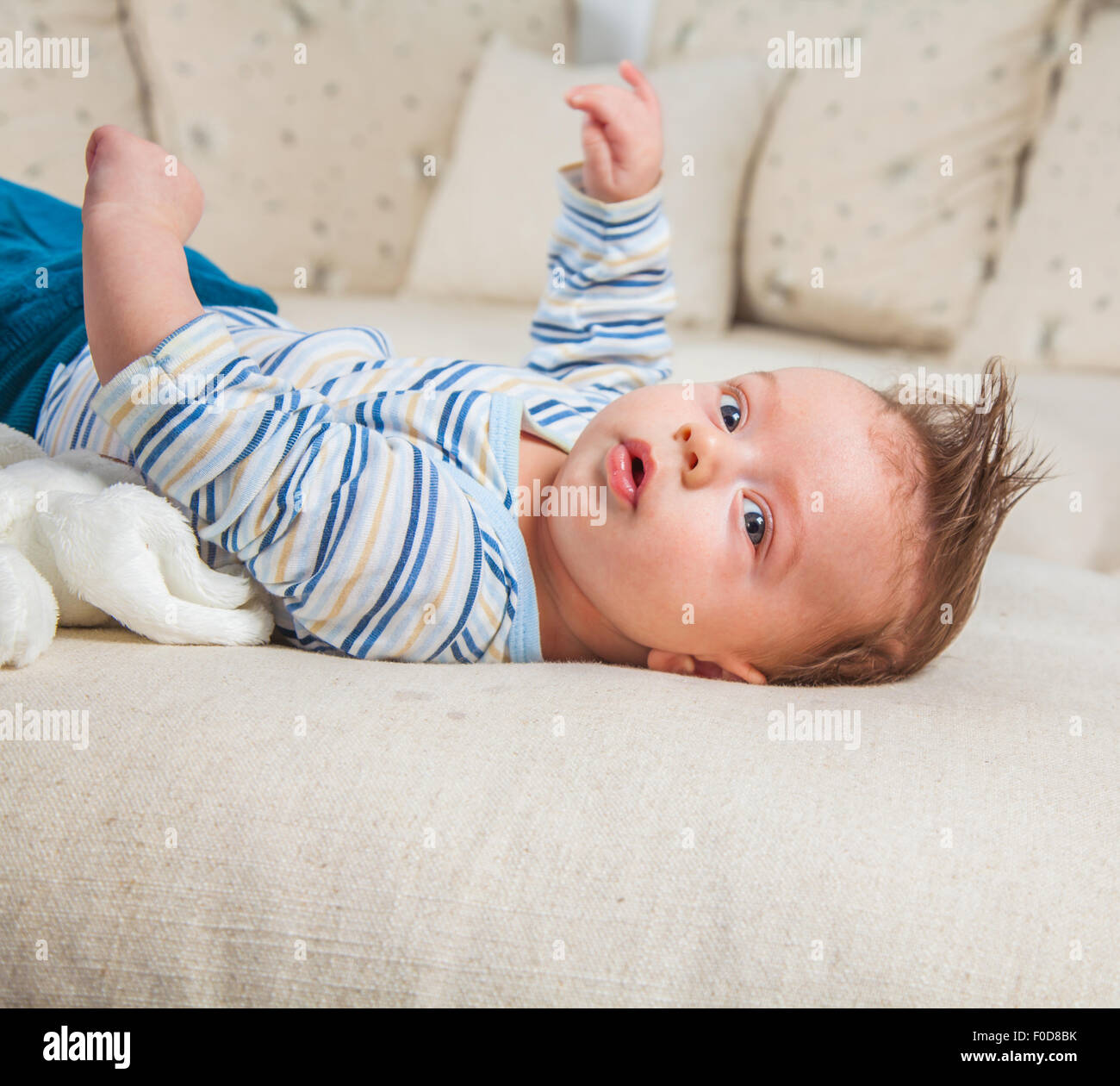 Cute 2 months old baby boy at home laying on his back on the sofa Stock ...