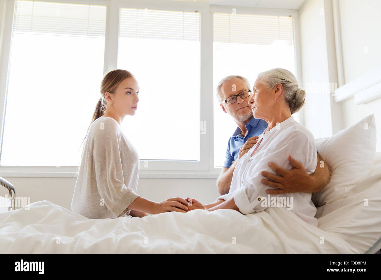 family visiting ill senior woman at hospital Stock Photo - Alamy