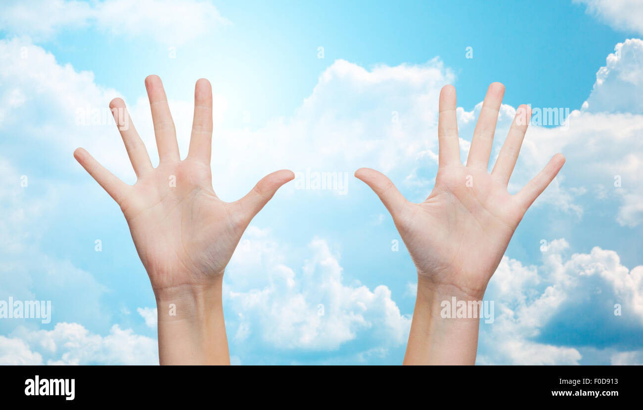 two woman hands making high five over blue sky Stock Photo - Alamy