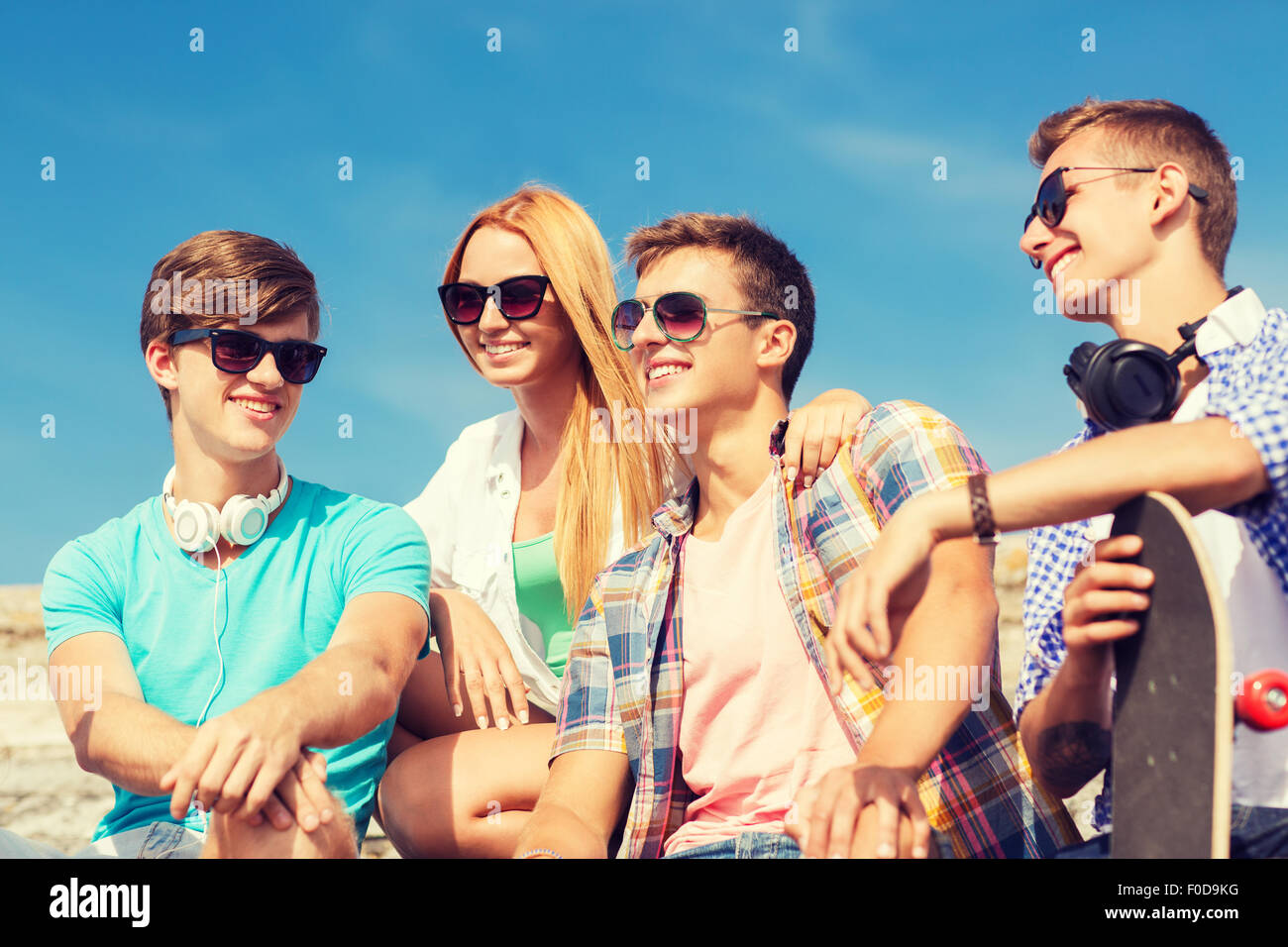 group of smiling friends sitting on city street Stock Photo - Alamy