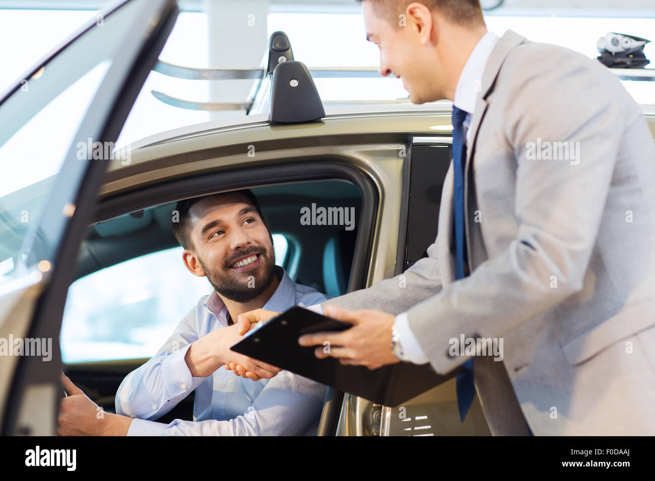 happy man with car dealer in auto show or salon Stock Photo - Alamy