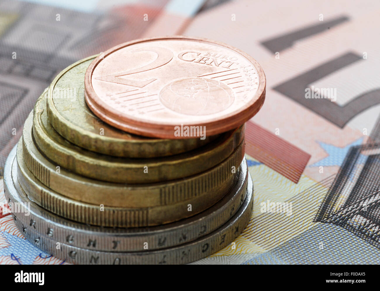Two cent coin on Euro coins and banknotes Stock Photo - Alamy