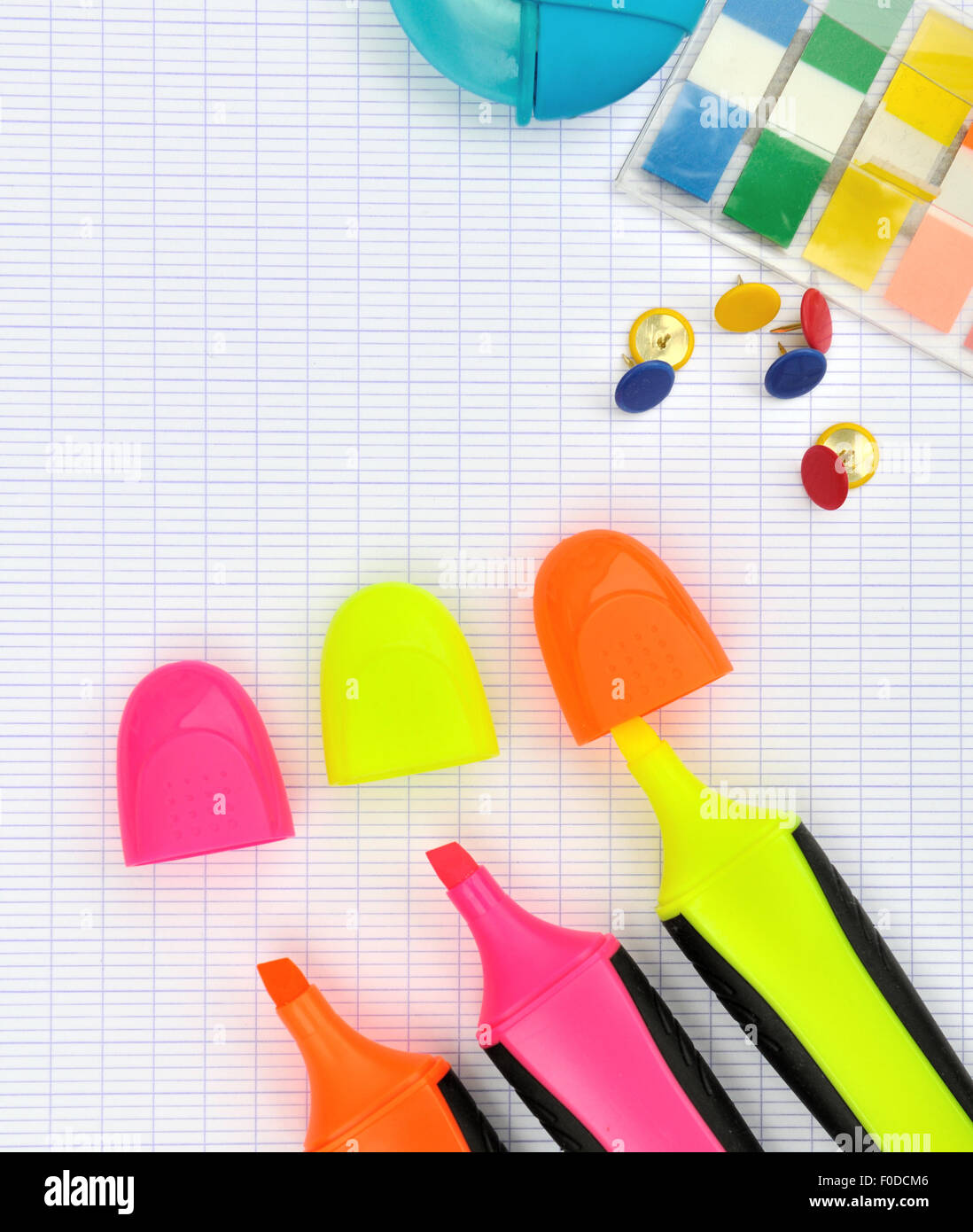 highlighters open with their caps and other office suppllies on white ...