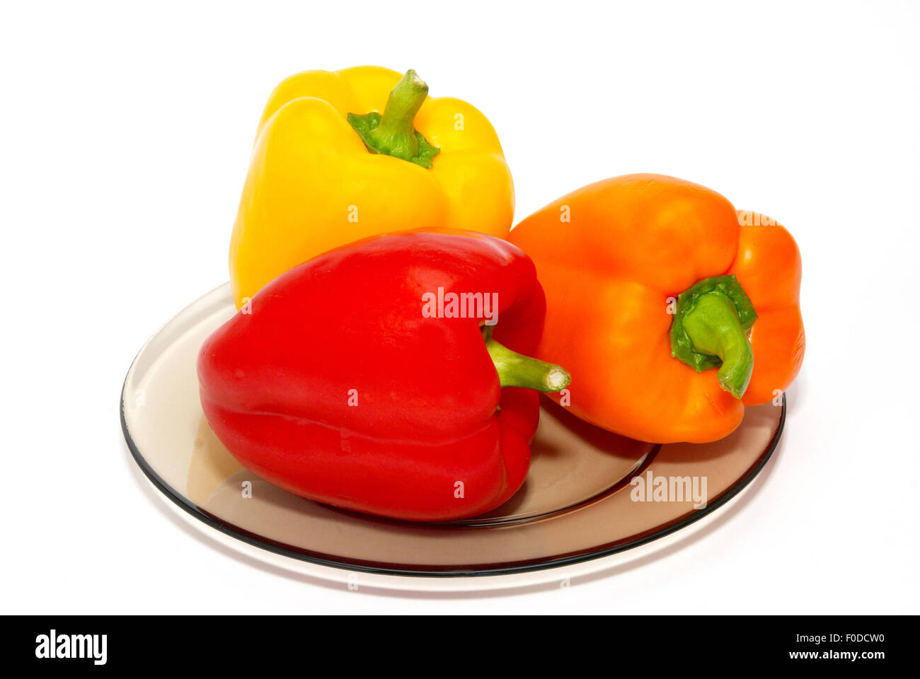 Three colored paprika on the plate on white background Stock Photo - Alamy