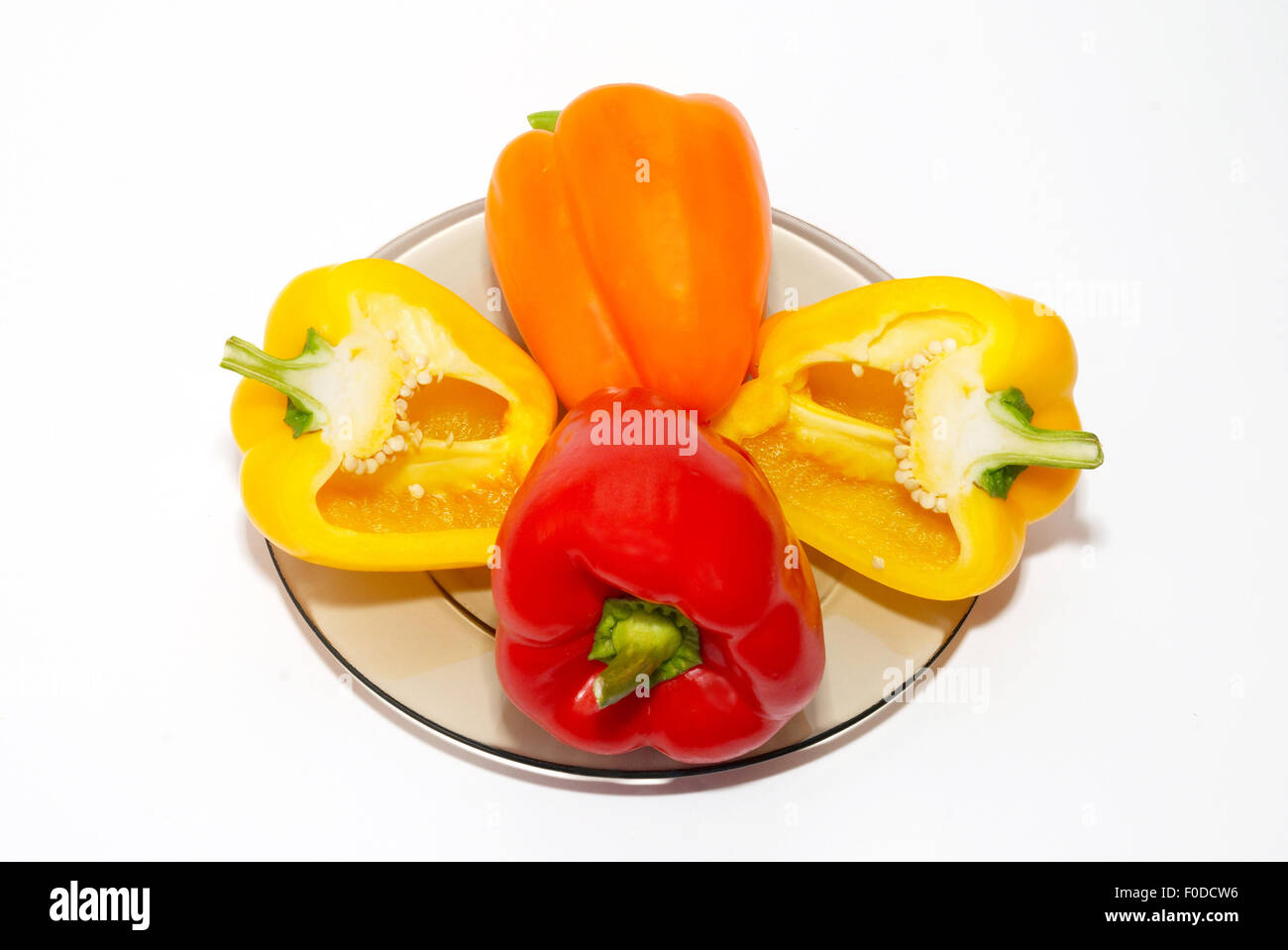 Three colored paprika on the plate on white background Stock Photo - Alamy