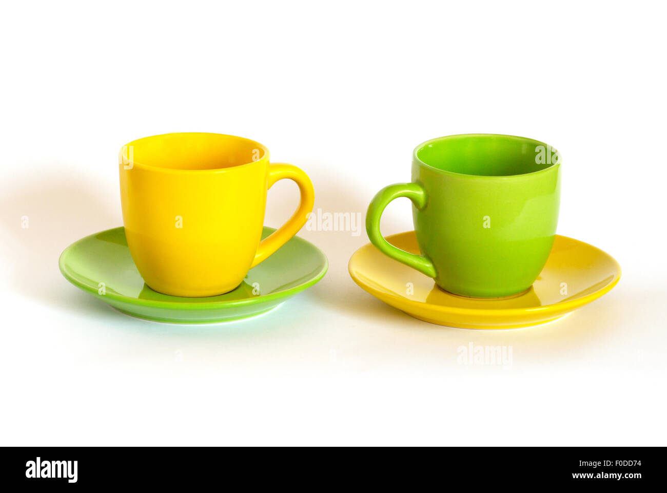 Two colored tea cups and saucers on white background Stock Photo - Alamy
