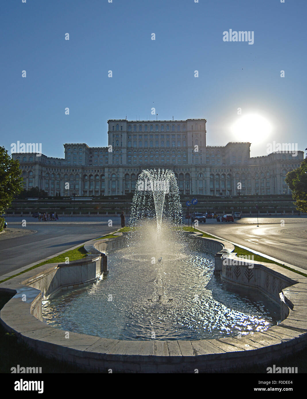 Fountain on Unirii Boulevard with Parliament and evening sun as ...