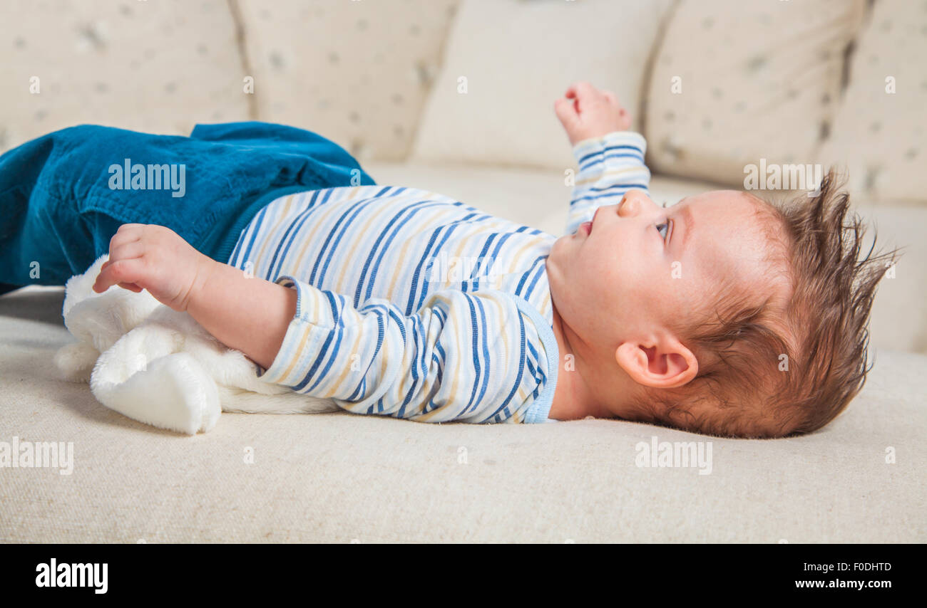 Cute 2 months old baby boy at home laying on his back on the sofa Stock ...