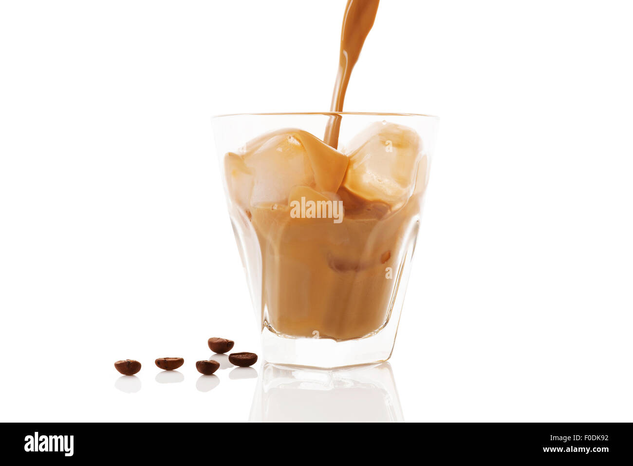 Ice coffee. Pouring ice coffee into glass with ice isolated on white ...
