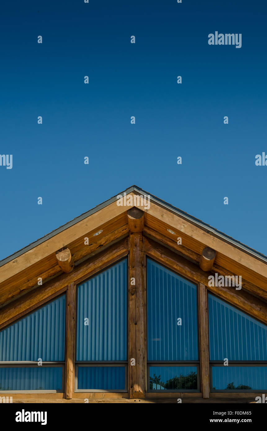 The triangular roofline of a log cabin against a clear blue sky Stock ...