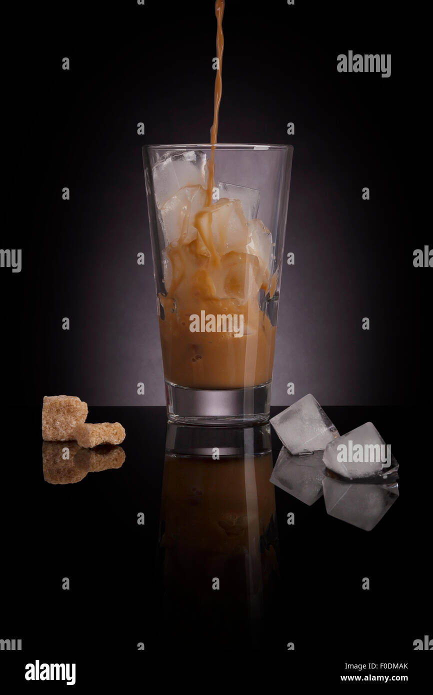 Delicious ice coffee with melting ice cubes and brown sugar on dark ...
