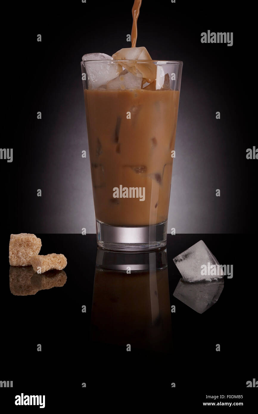 Ice coffee with melting ice cubes and brown sugar on dark background ...