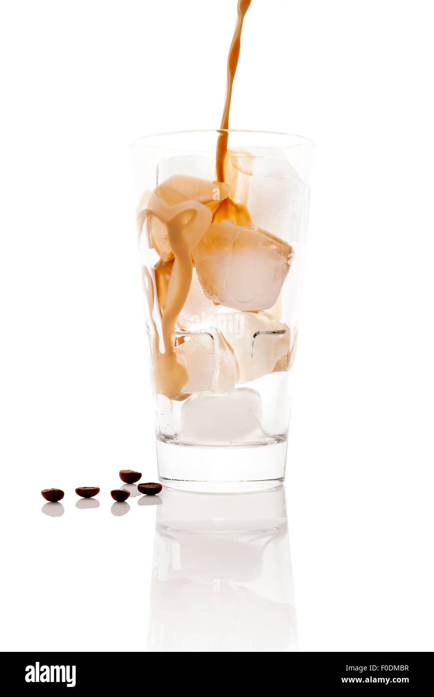 Pouring ice coffee into glass with ice cubes isolated on white ...