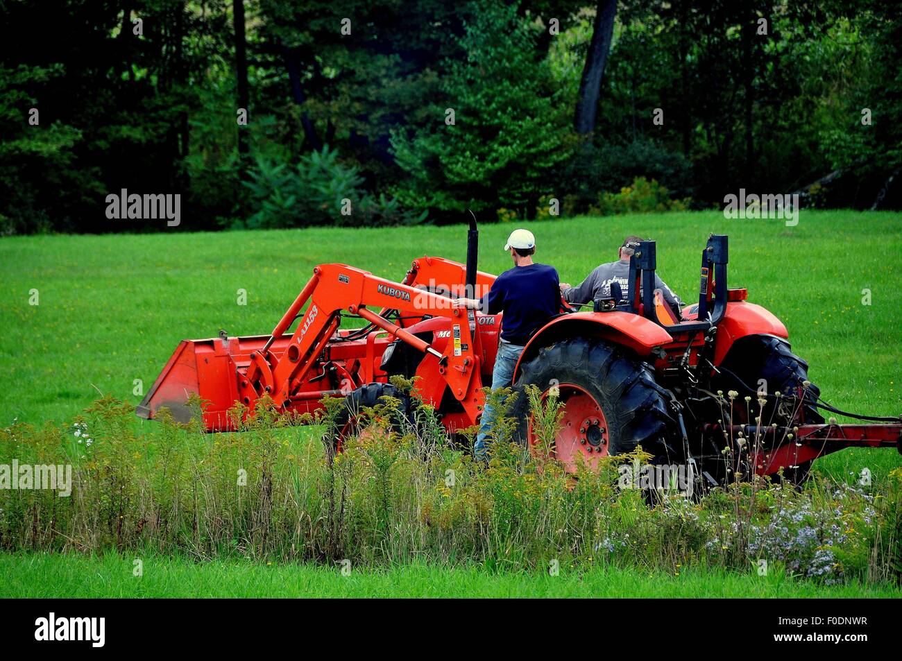 Conway, Massachusetts: Farmers on a large tractor prepare to plow a ...
