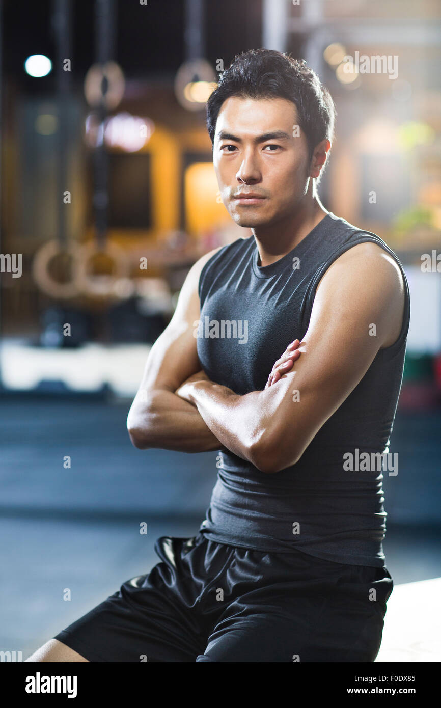Young man sitting at gym Stock Photo - Alamy