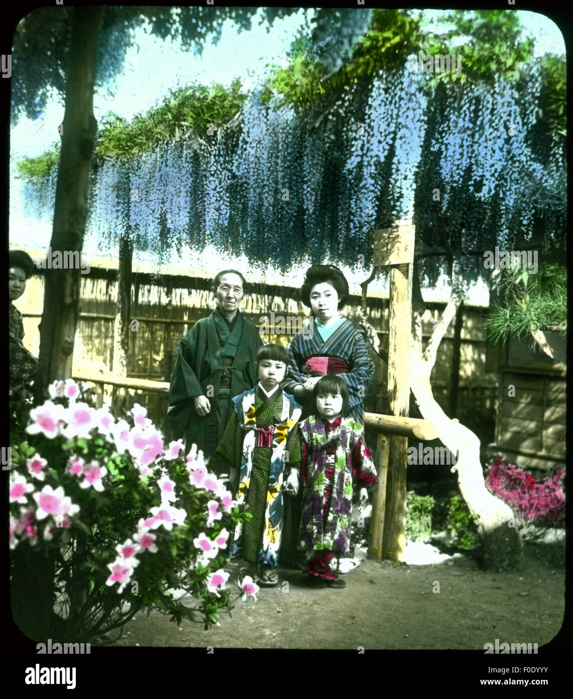 A family in traditional attire poses for a portrait in a garden. This ...