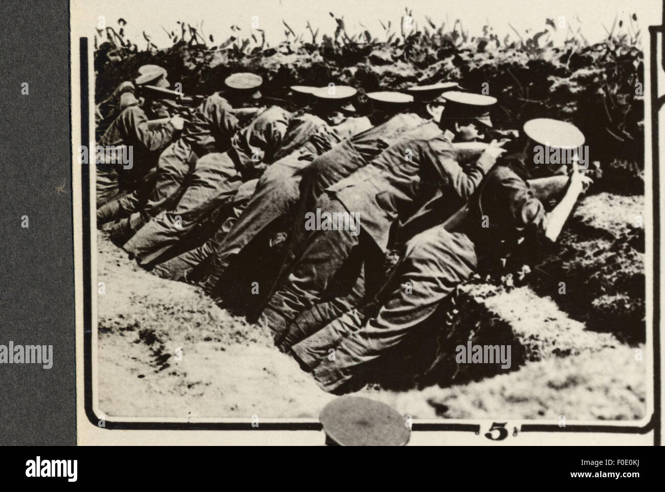 This photograph depicts soldiers firing from the trenches, a common ...