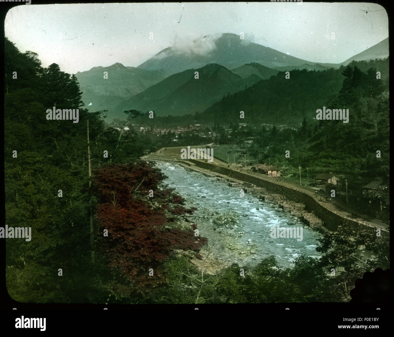 This image depicts a river with a manmade embankment and a road running ...