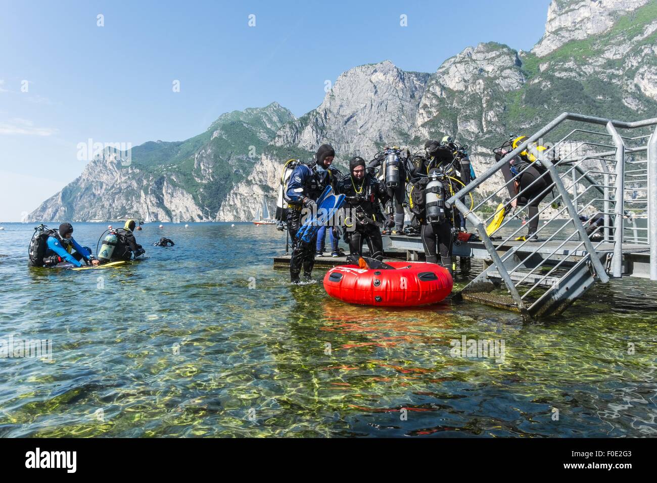 Scuba divers getting ready for immersion at Lake Garda, preparing their ...