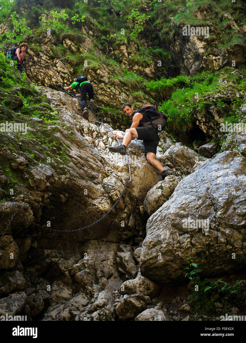 Group of hikers with backpacks descending on a difficult trail on ...