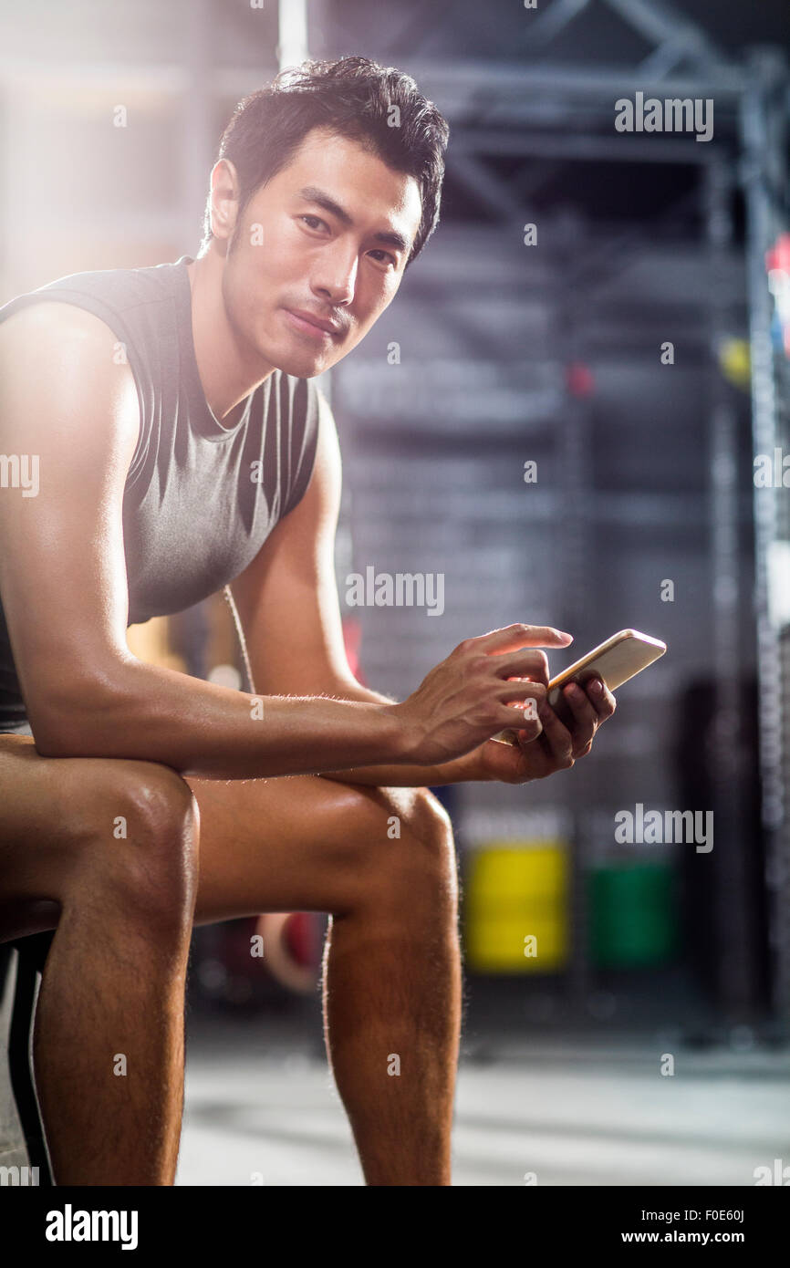 Young man using smart phone in gym Stock Photo - Alamy