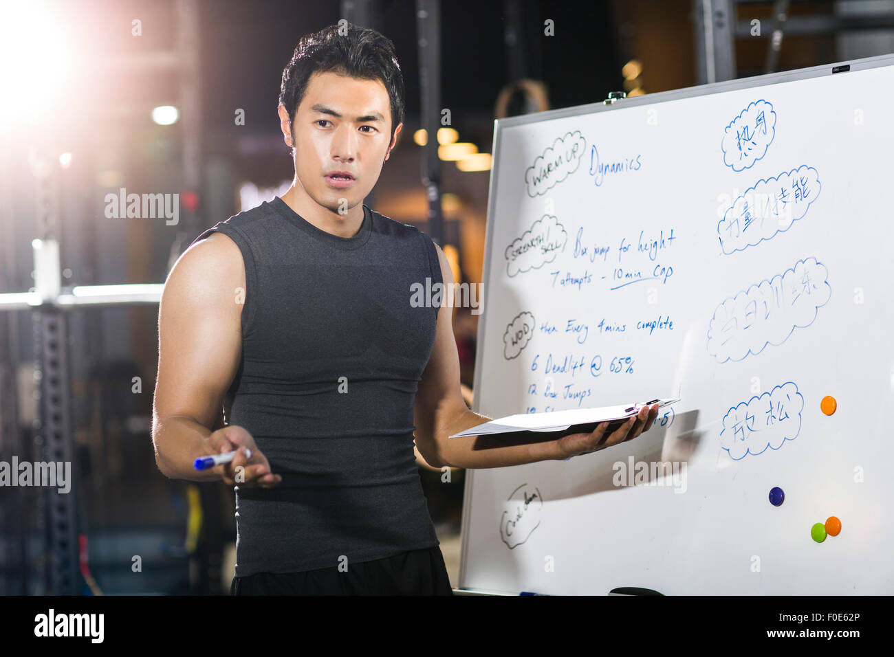 Coach making exercise plan in gym Stock Photo - Alamy