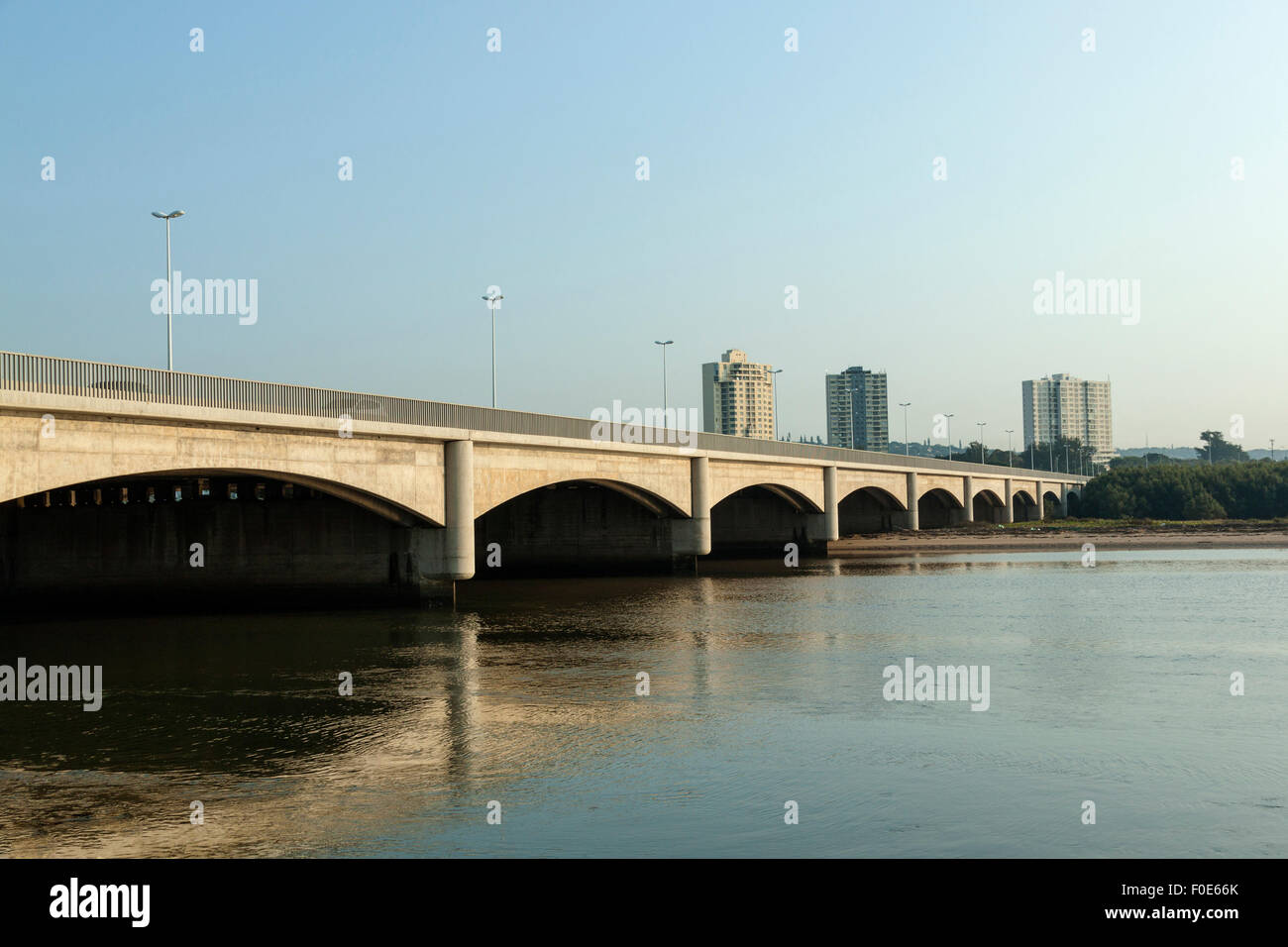 Arched bridge over Umgeni river with apartment buildings in background ...