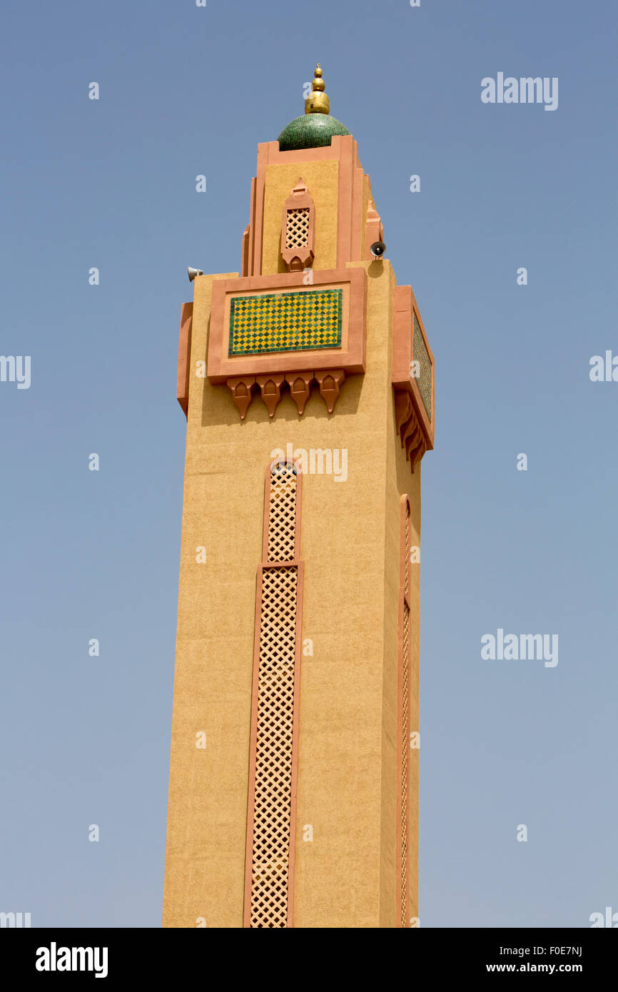 Minaret of a mosque in a small and remote village against a blue sky in ...