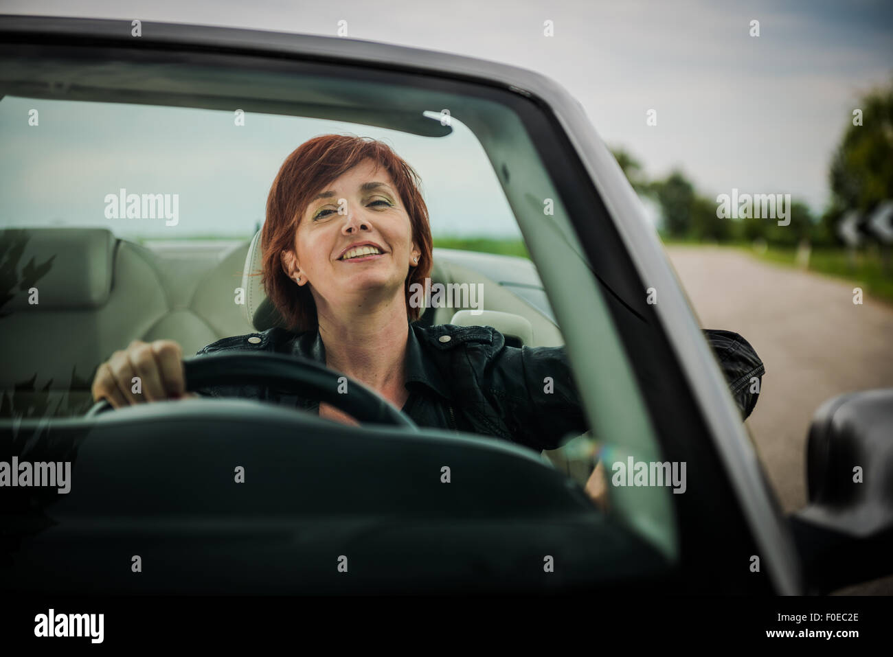 Woman enjoying driving her convertible car Stock Photo - Alamy