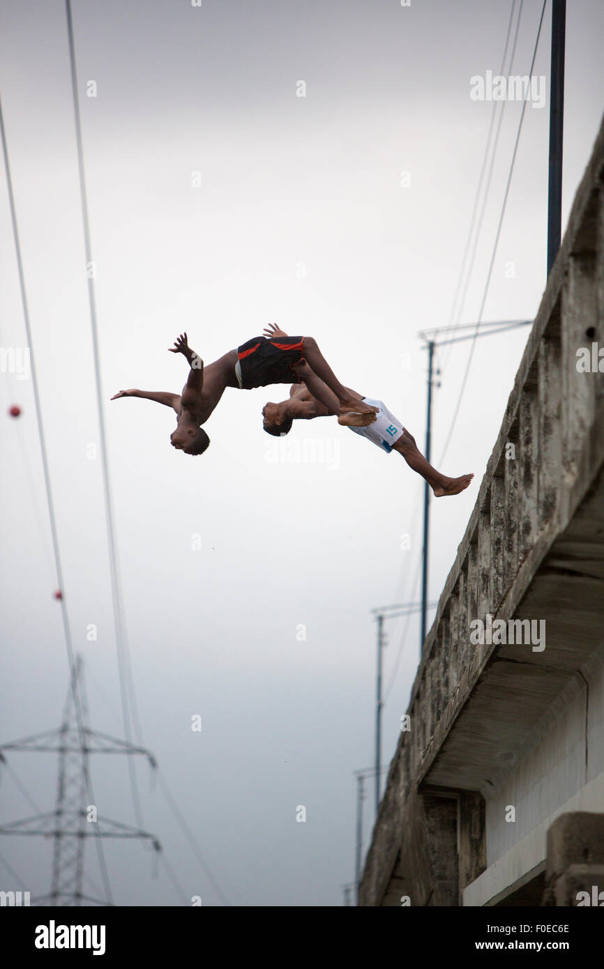 Two unidentified teenagers jumping back side from a tall concrete ...