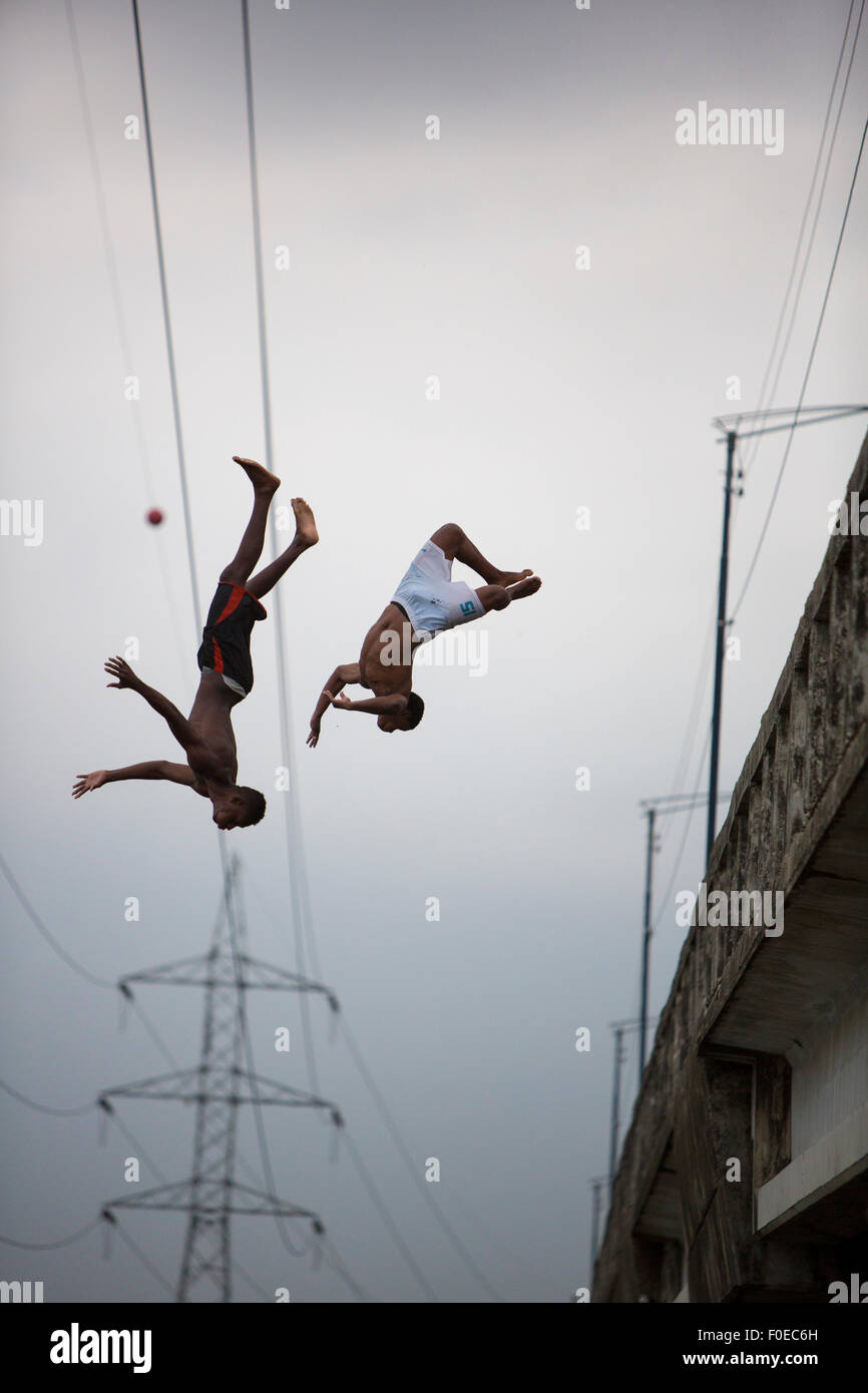 Two unidentified teenagers jumping back side from a tall concrete ...