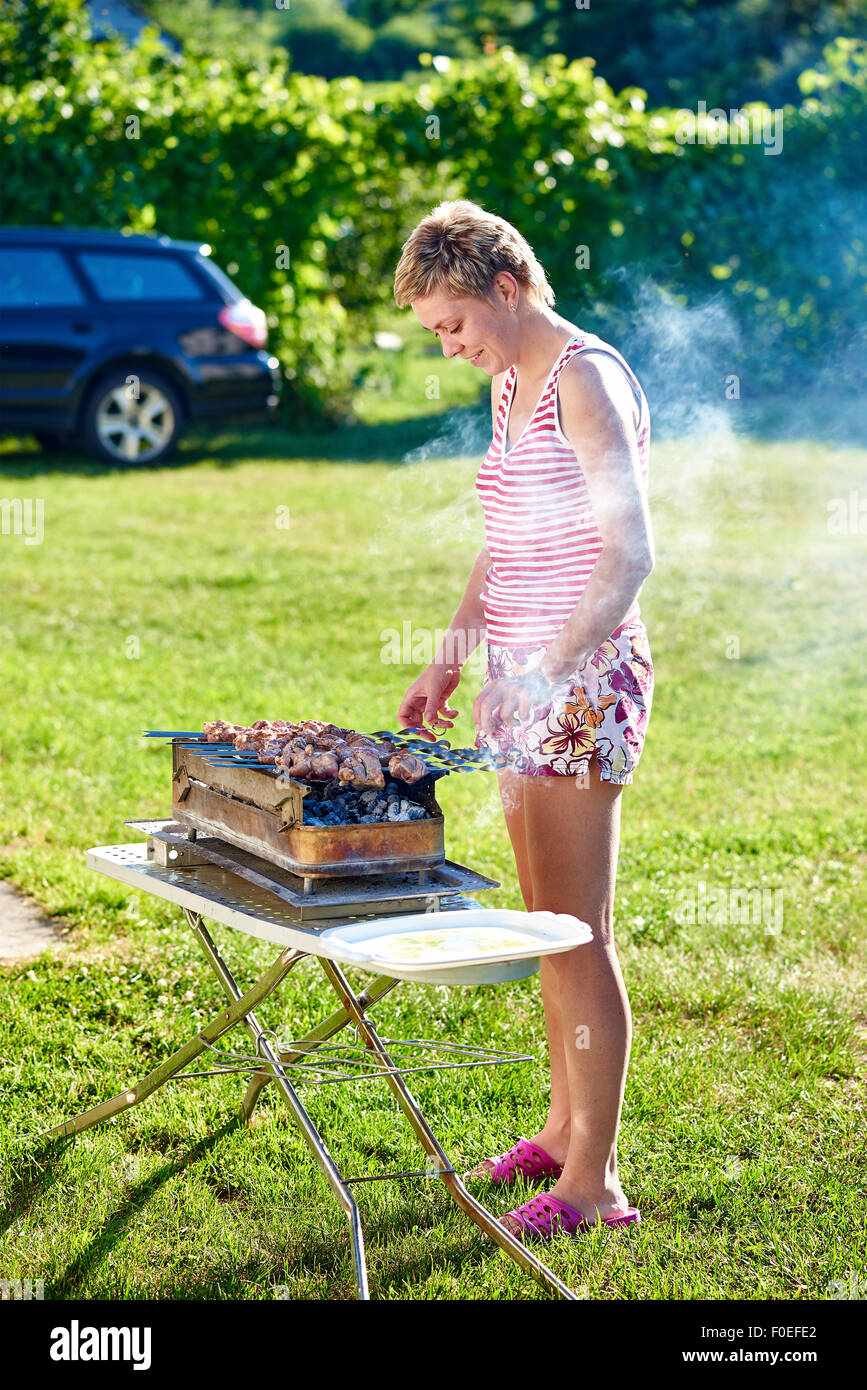 Pretty girl cooking barbecue outdoors Stock Photo - Alamy