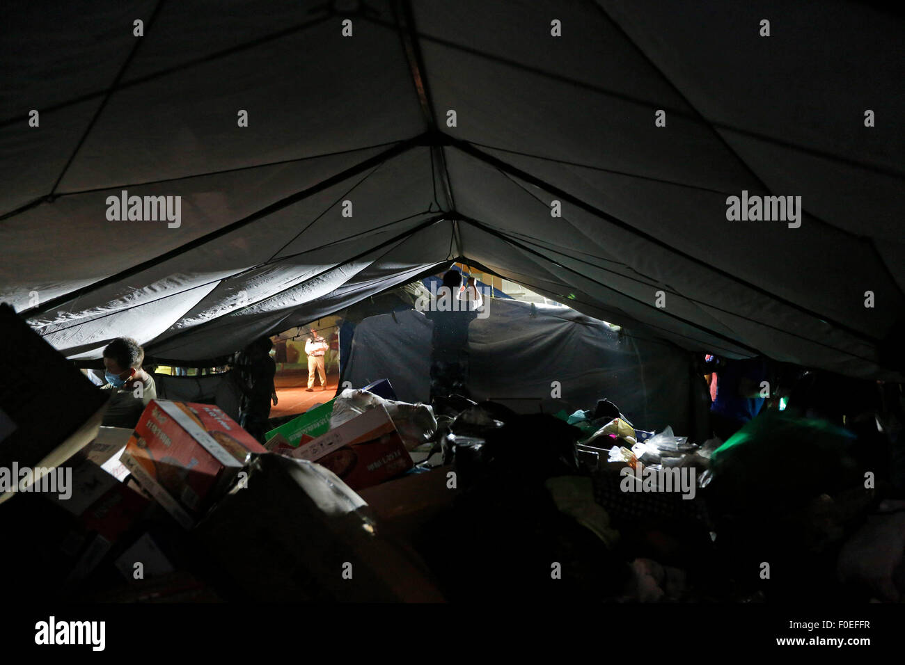 Tianjin, China. 13th Aug, 2015. Volunteers erect tents at a temporary ...